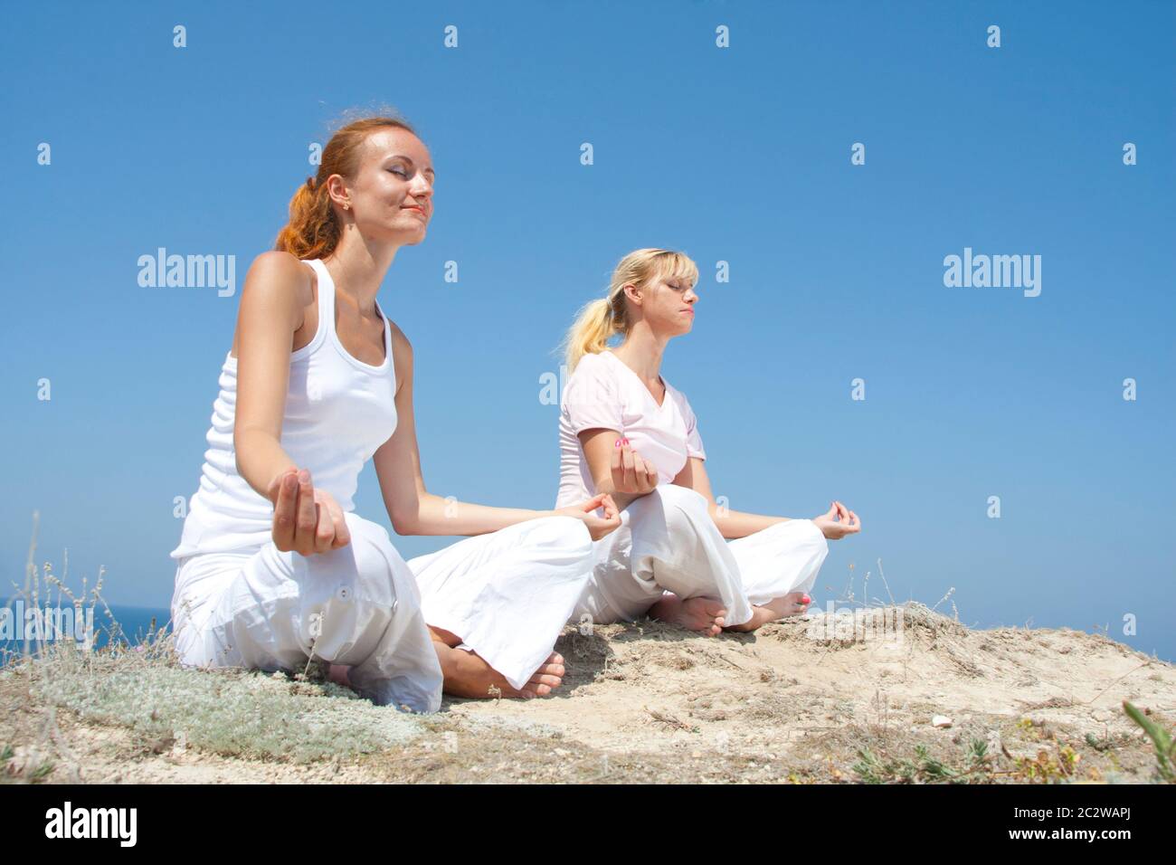 Woman in yoga position meditating in the mountains hi-res stock ...