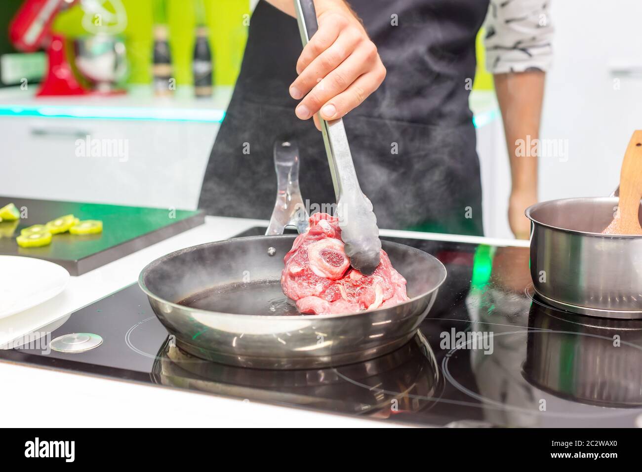 Young man cooking meat hi-res stock photography and images - Alamy