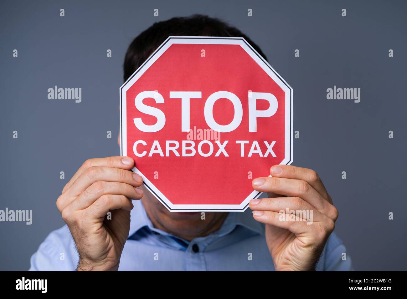 Man Hiding His Face Behind Stop Red Sign With Carbon Tax Text Over Grey ...