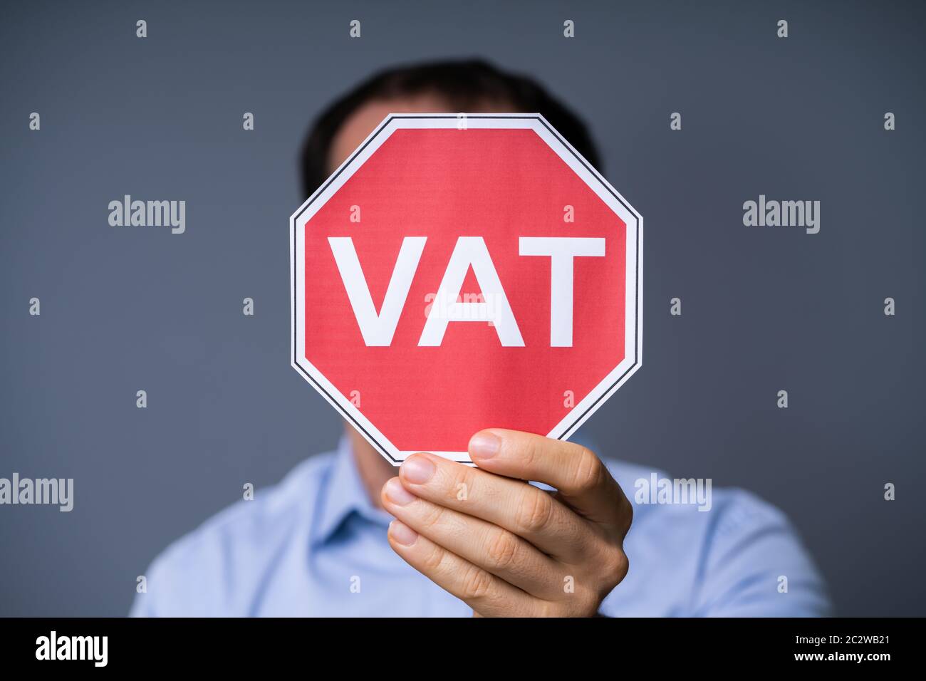 Man Holding Stop Red Sign With Vat Text In Front Of Face Over Grey ...