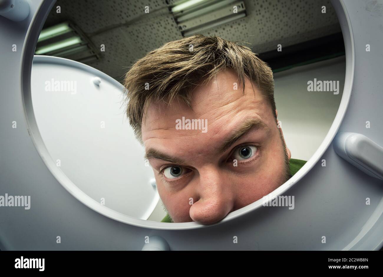 Bizarre man in the bathroom looking in the toilet bowl Stock Photo - Alamy