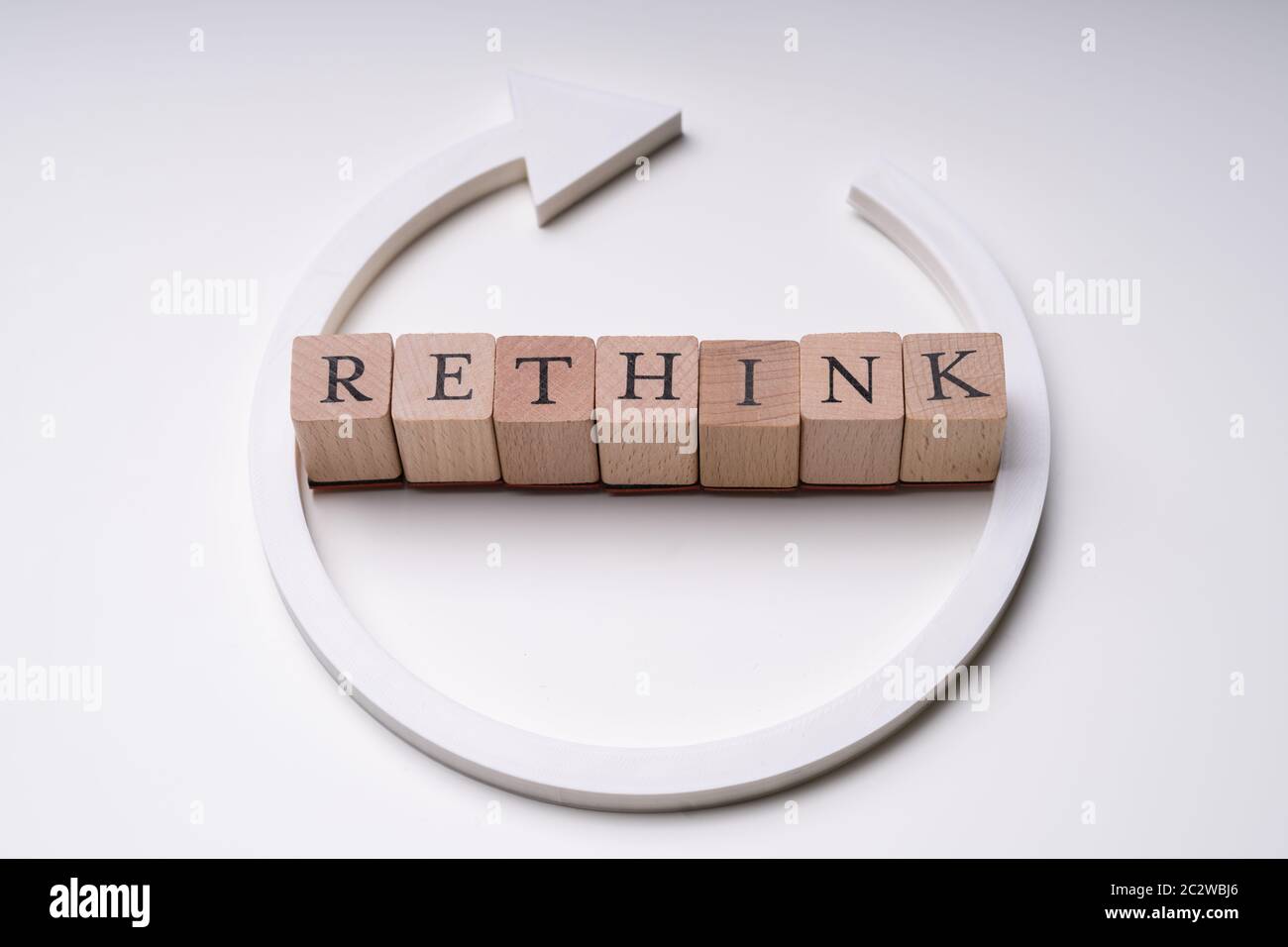 Close-up Of Rethink Word On Wooden Blocks Near White Directional Arrow ...