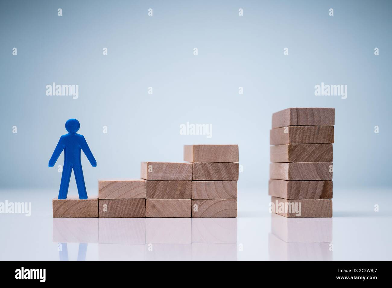 Human Model Of A Businessman Standing On Wooden Blocks Stacking As Step ...