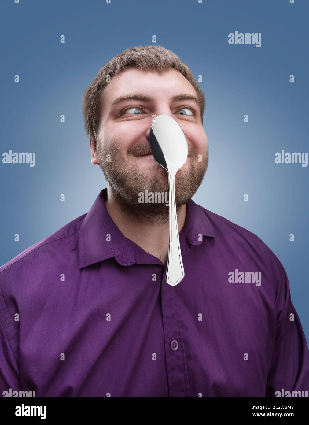 Strange adult man holds a spoon on his nose Stock Photo - Alamy