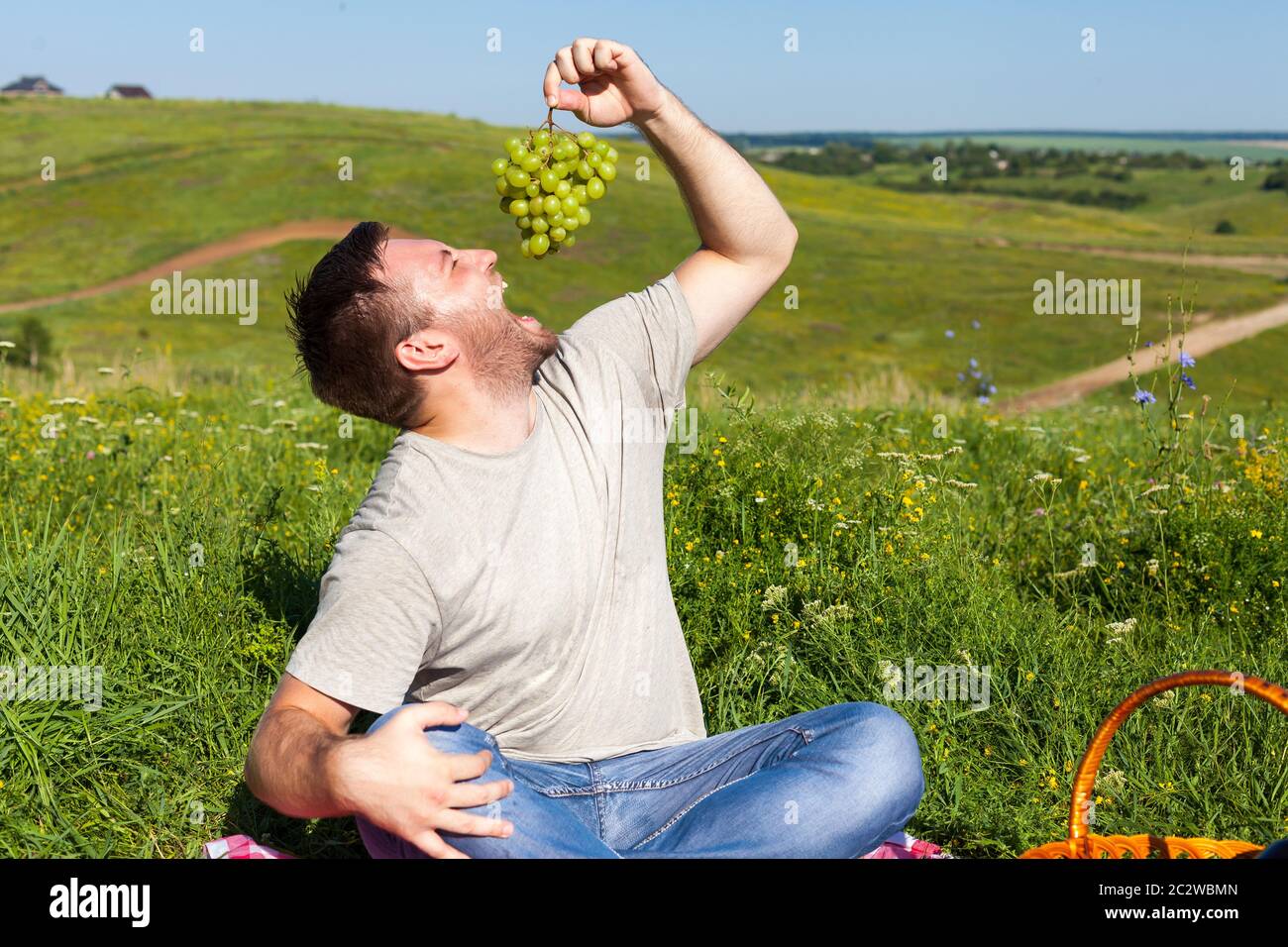 Man on the picnic alone is going to eat grape Stock Photo - Alamy