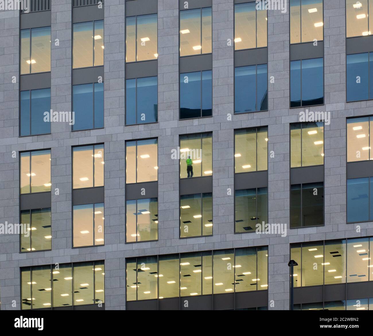 a construction worker standing in the window of a large new office ...