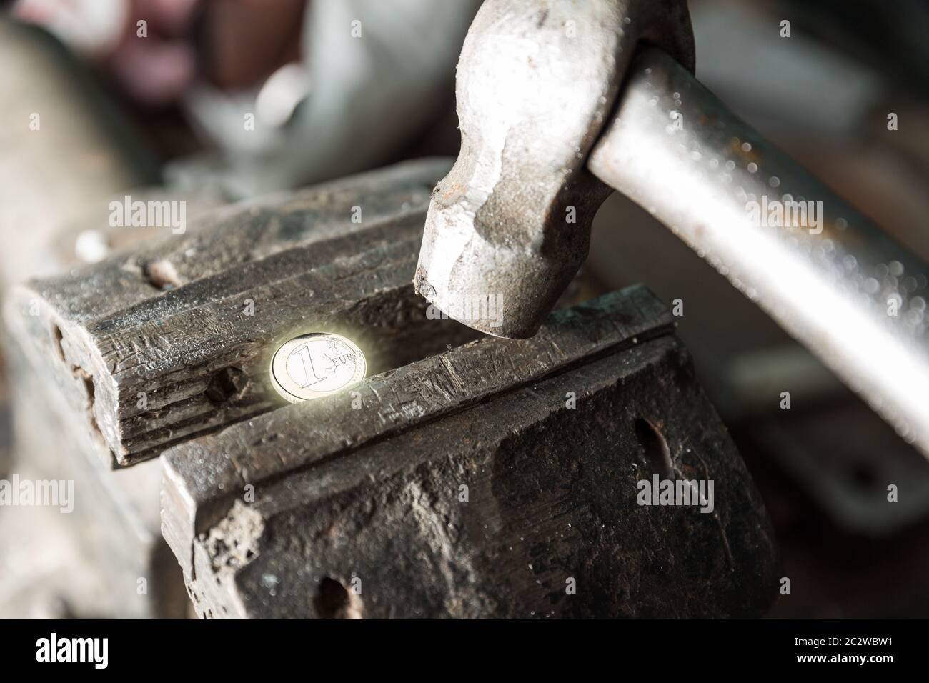 Metal bench vice with 1 euro coin and a hammer Stock Photo - Alamy