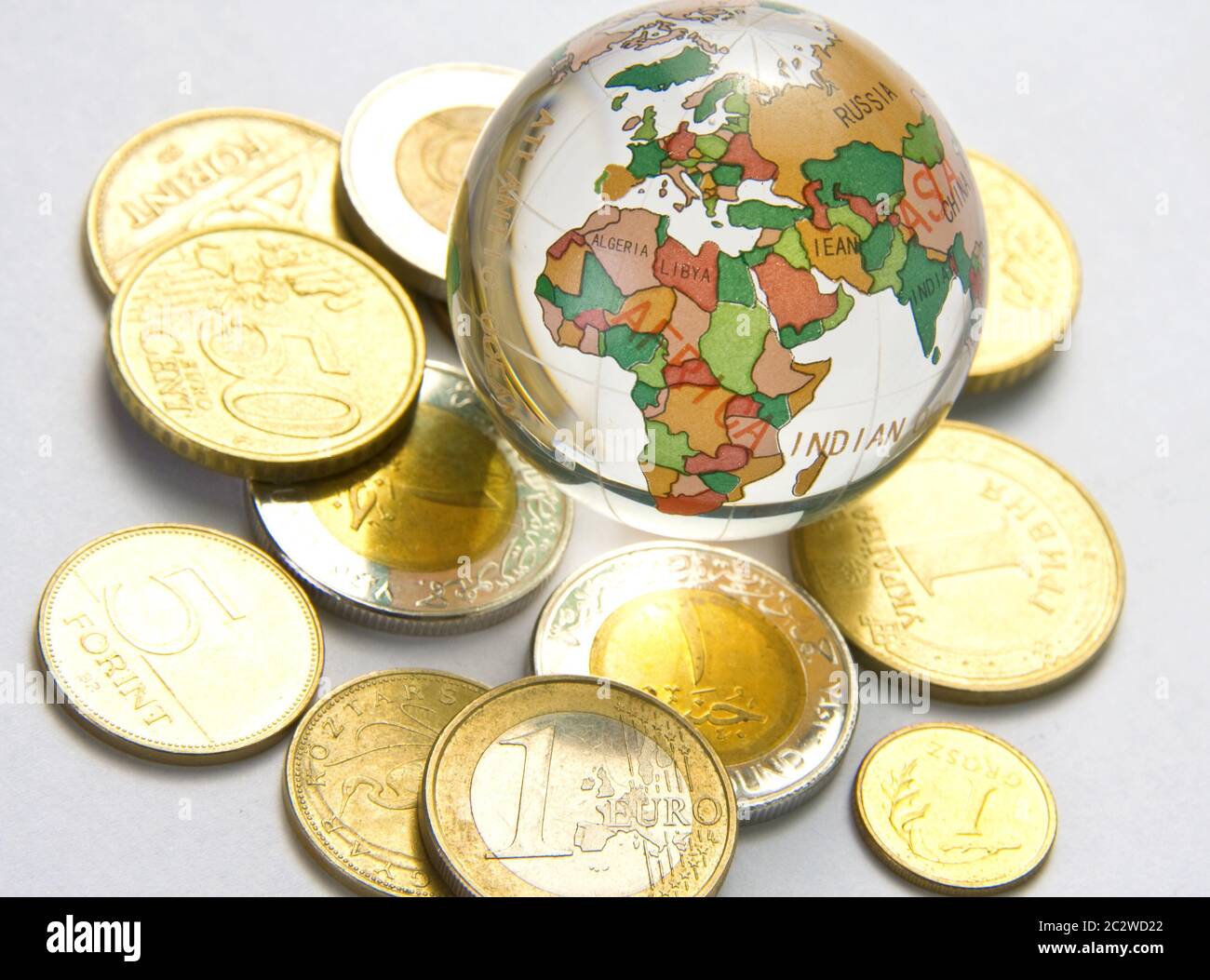World globe and different coins Stock Photo - Alamy