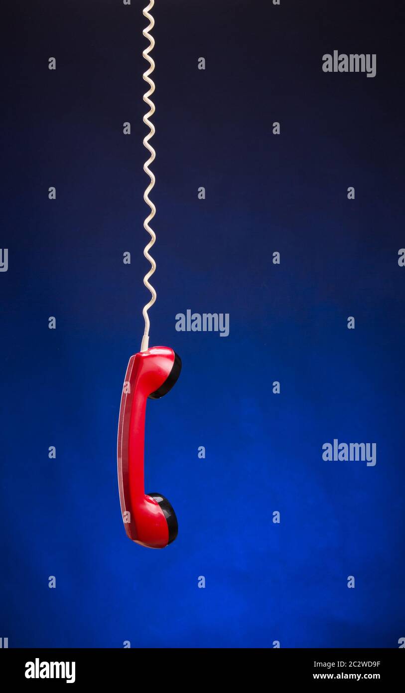 Red telephone handset is hanging Stock Photo - Alamy