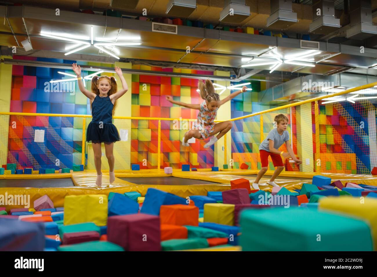 Little children having fun on kids trampoline, playground in ...