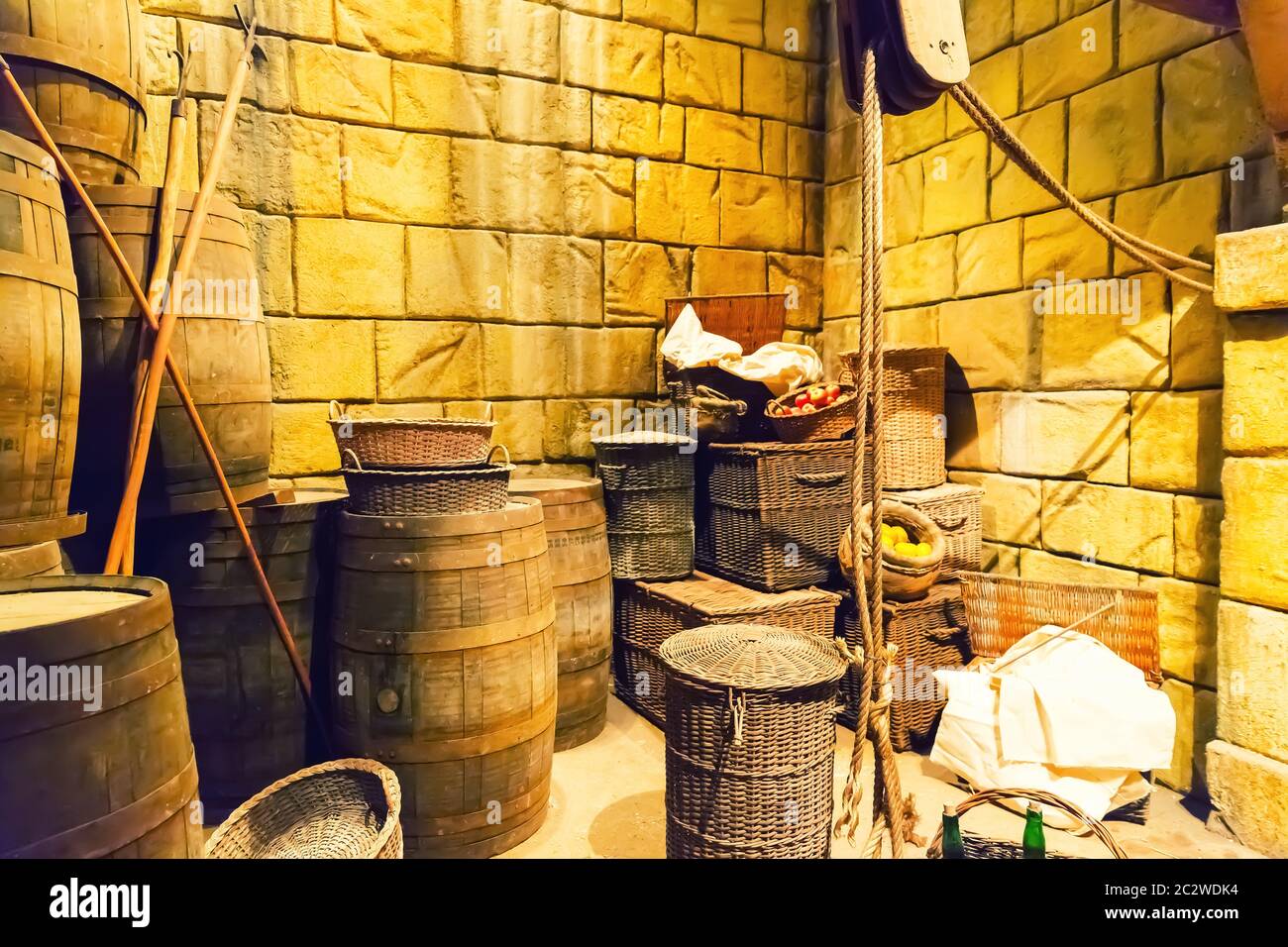 Old lit lumber room with wooden baskets, barrels and ropes Stock Photo ...