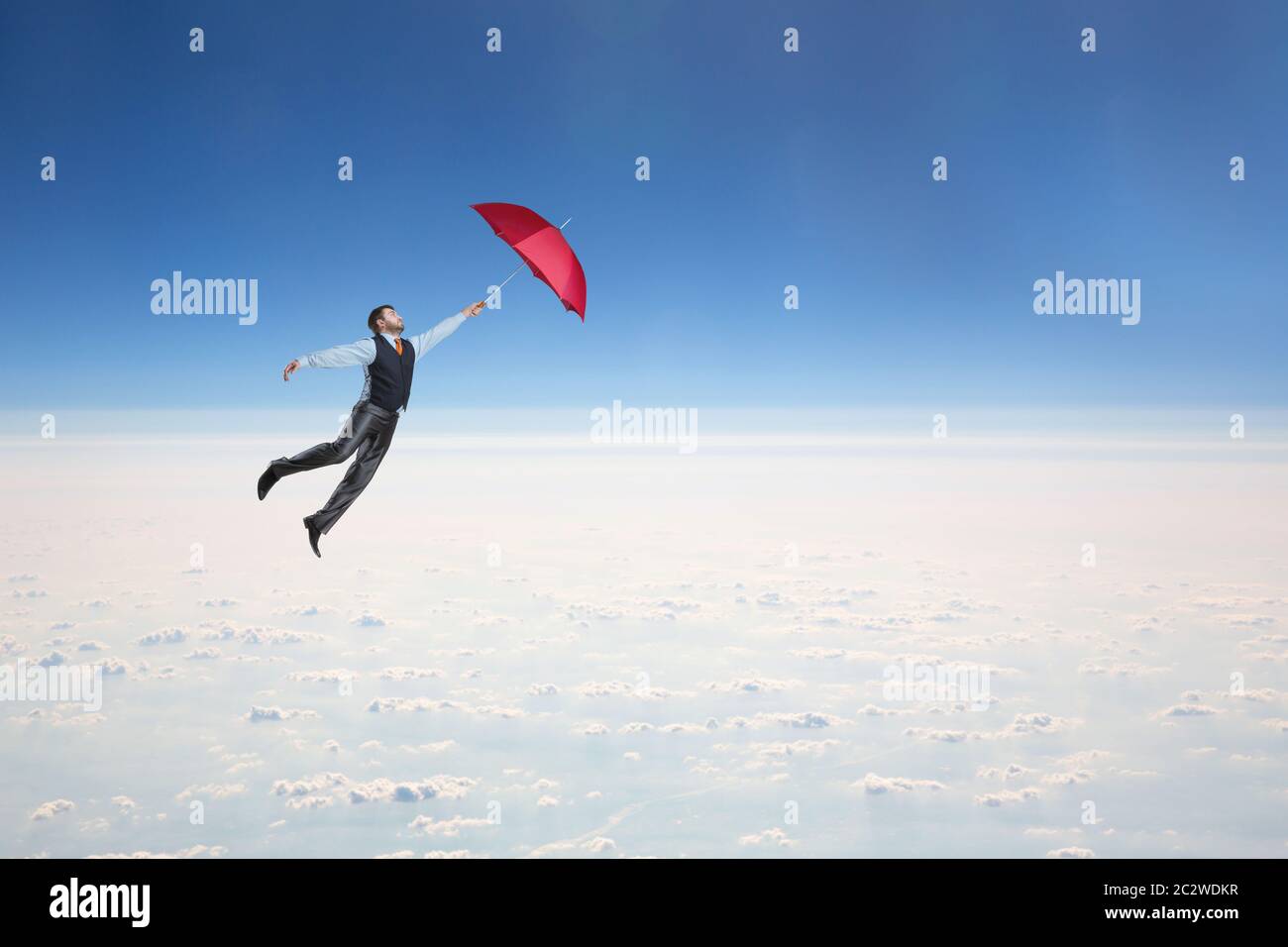 Man flying in the sky with red umbrella in his hand Stock Photo - Alamy