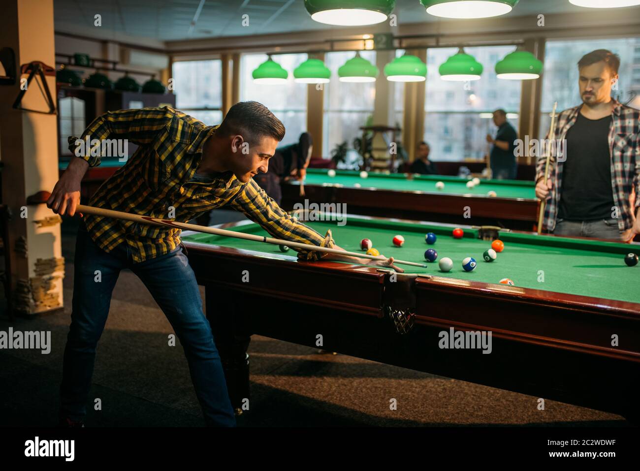 Two male billiard players spend time in poolroom. Men plays american ...