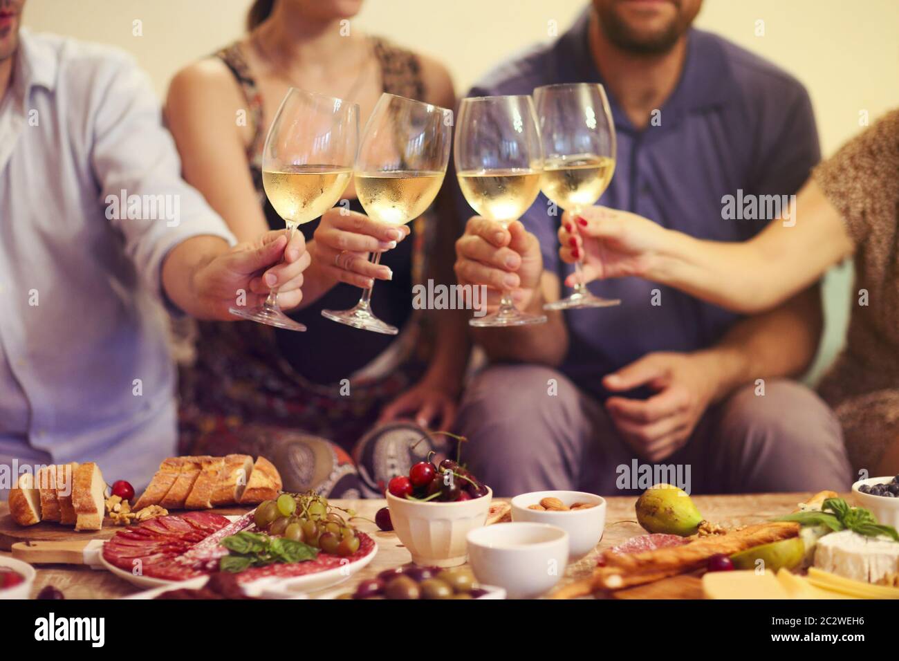 Hands of a group of people cheering with white wine Stock Photo - Alamy