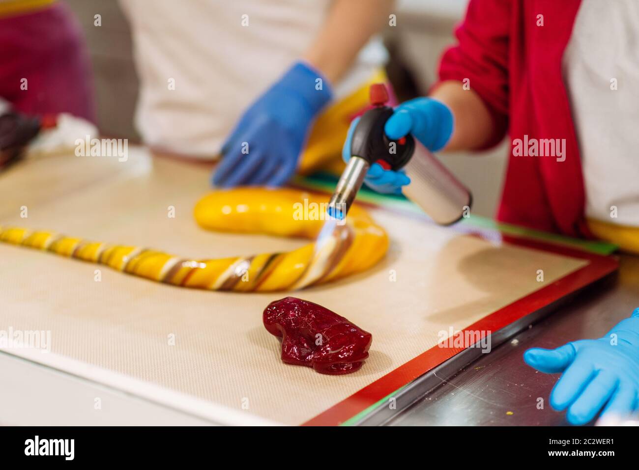Master melt caramel with a gas burner, lollipop making process. Candy ...