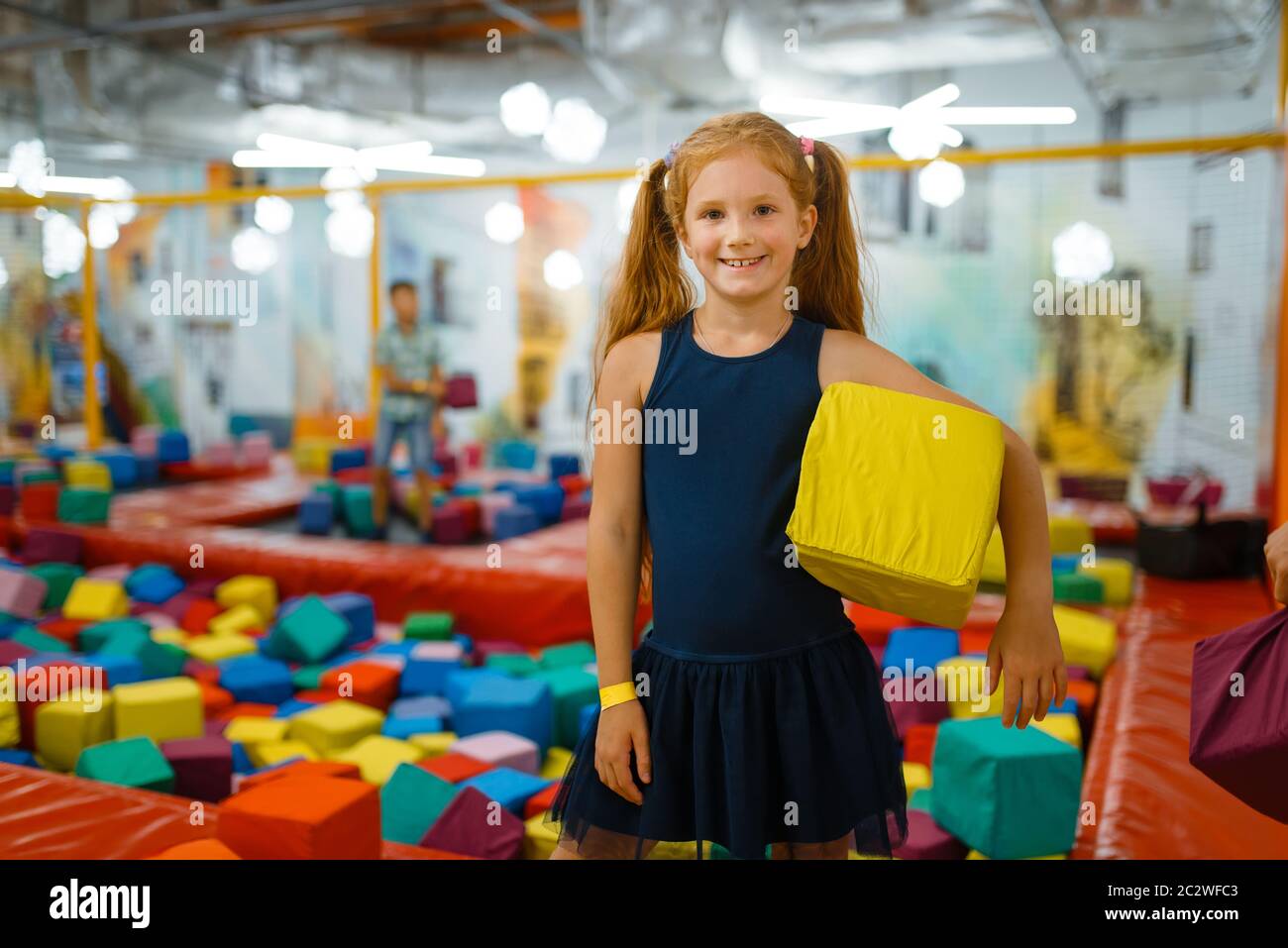 Adorable little girl playing with soft cube, playground in ...