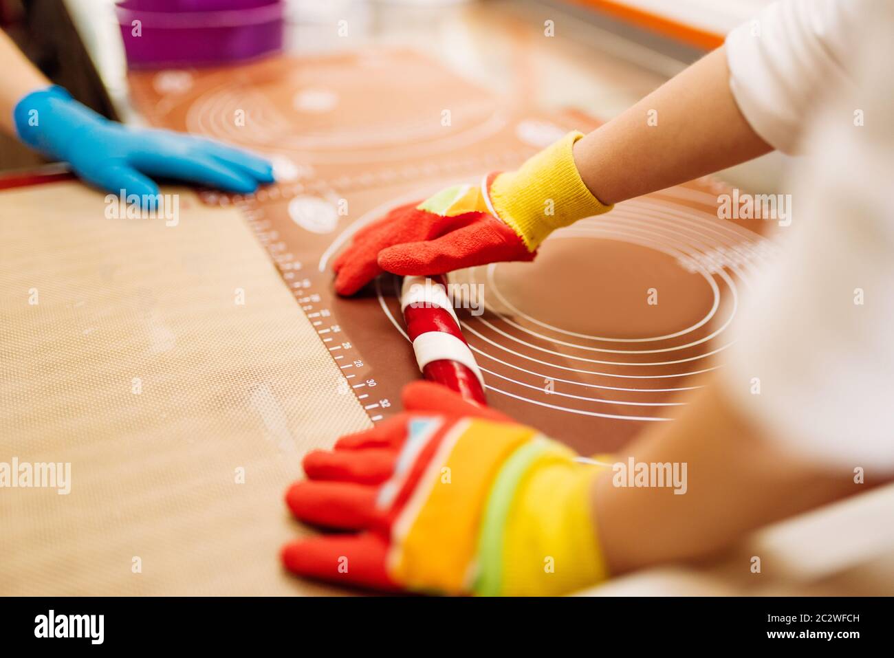 Male chef hands in gloves, caramel making process. Candy preparation in ...