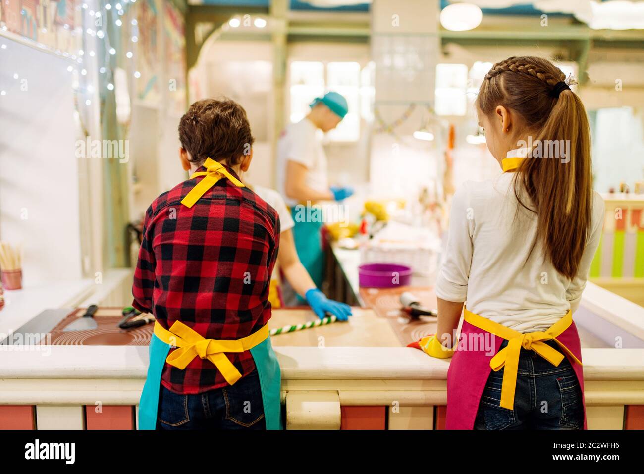 Children in workshop at pastry shop learn to make caramel. Holiday fun ...