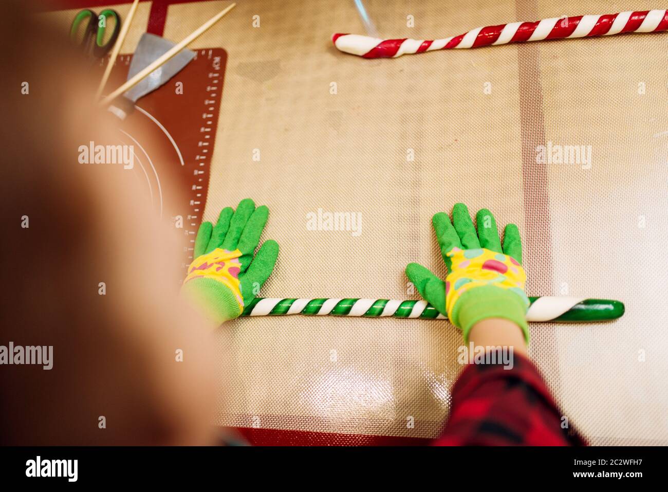 Male chef hands in gloves, caramel making process. Candy preparation in ...