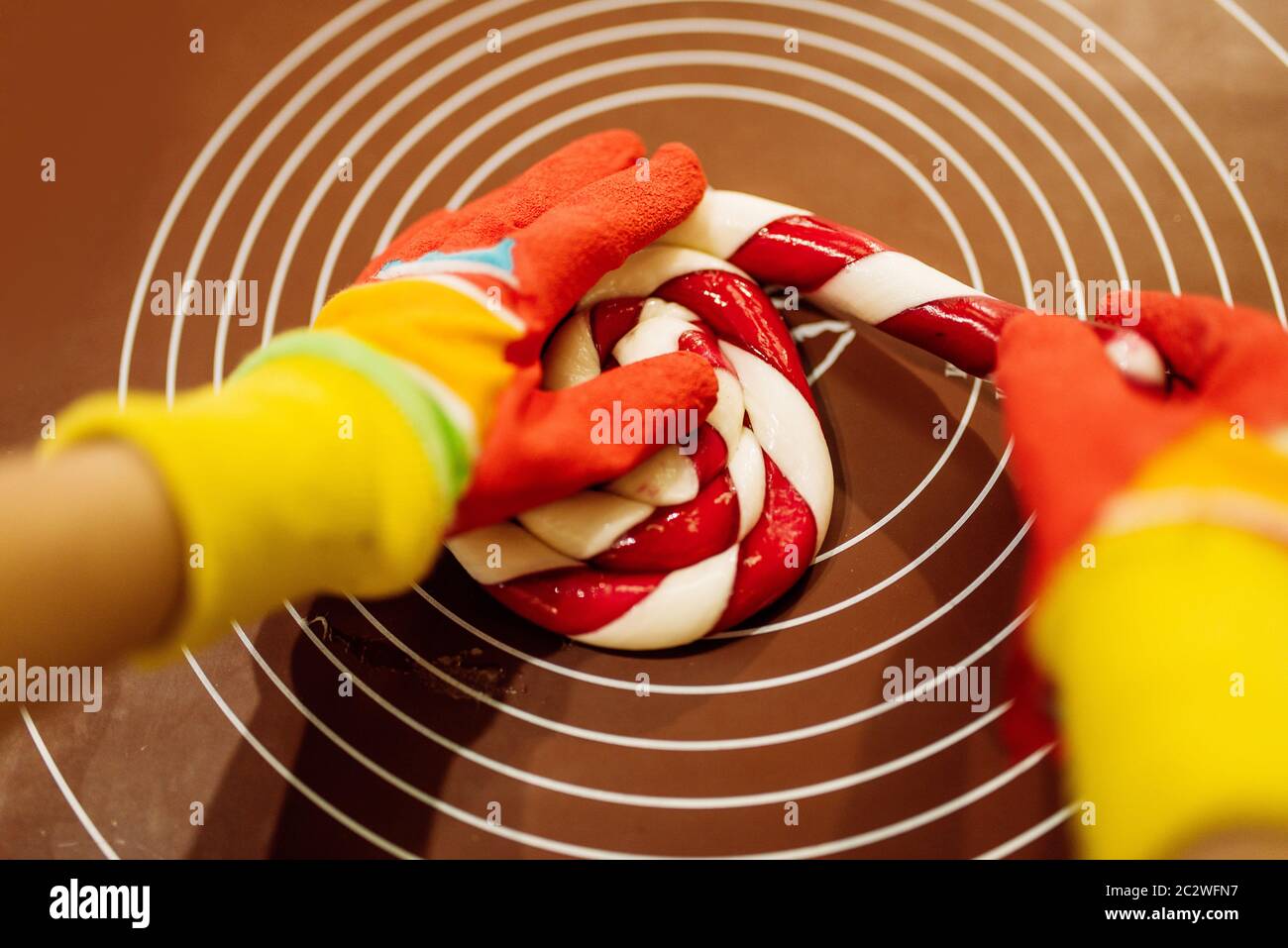 Kid hands in gloves making caramel sweets in workshop. Holiday fun in ...