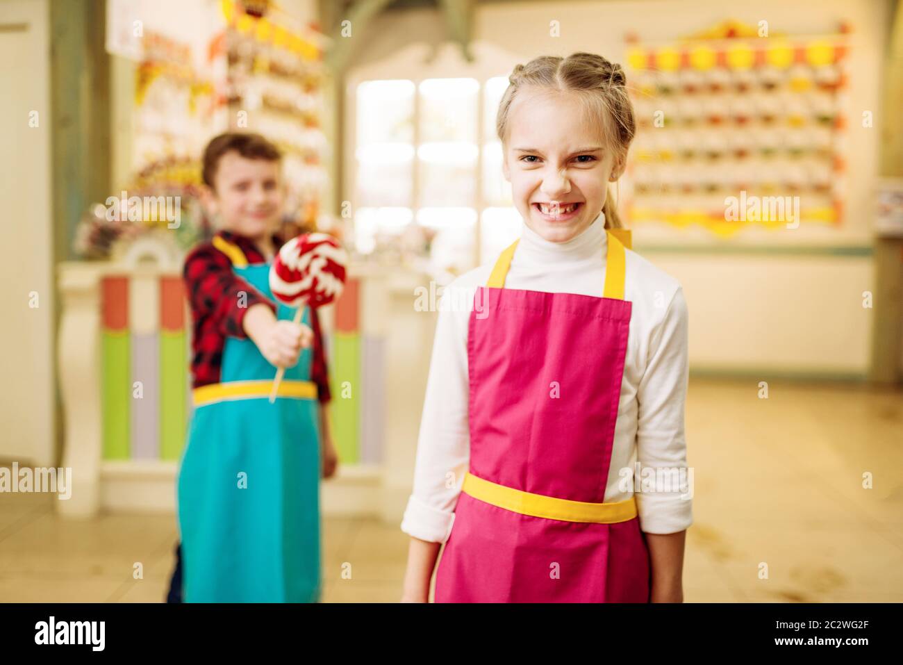 Little boy gives handmade lollipop to stubborn girl. Children in ...