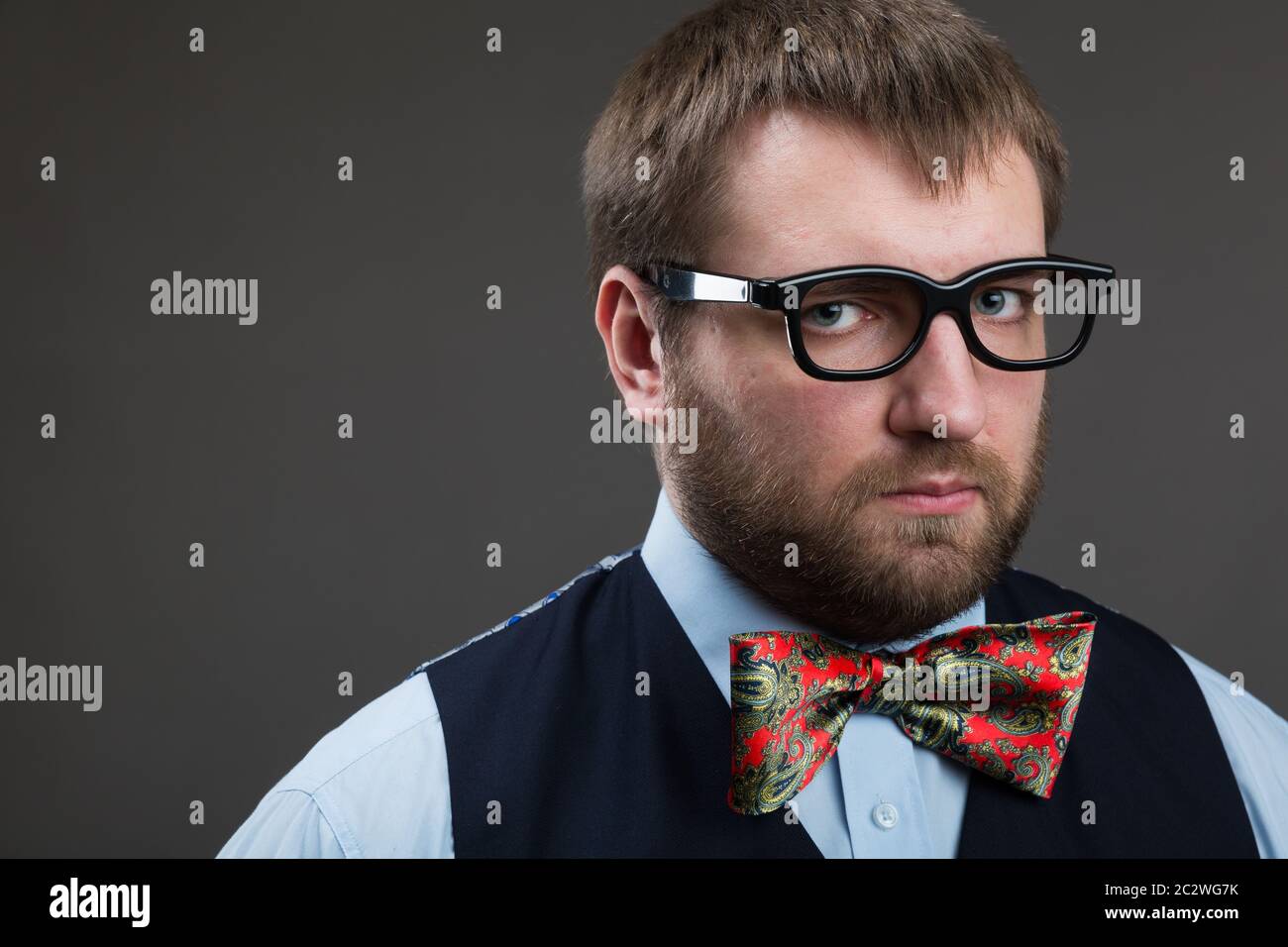 Suspicious man in glasses looks at you over grey background Stock Photo ...