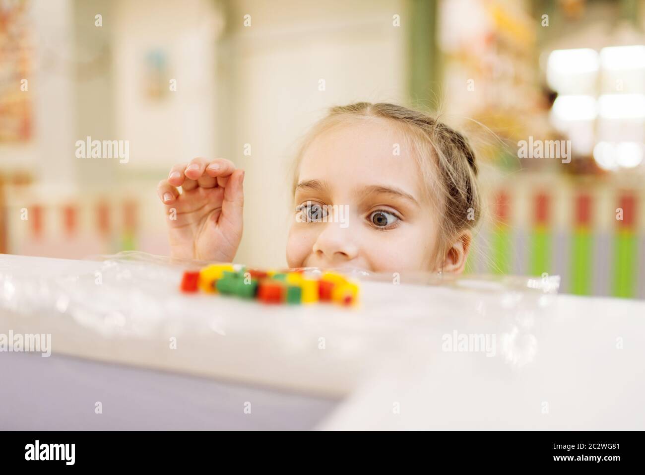 Happy petty thief takes handmade sweet from table in candy store ...