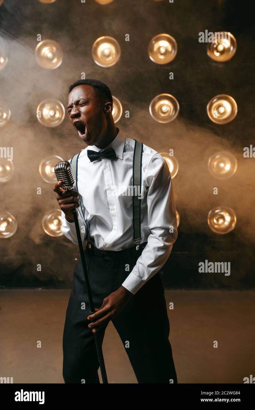 Black jazz performer singing on the stage. Black jazzman preforming on ...