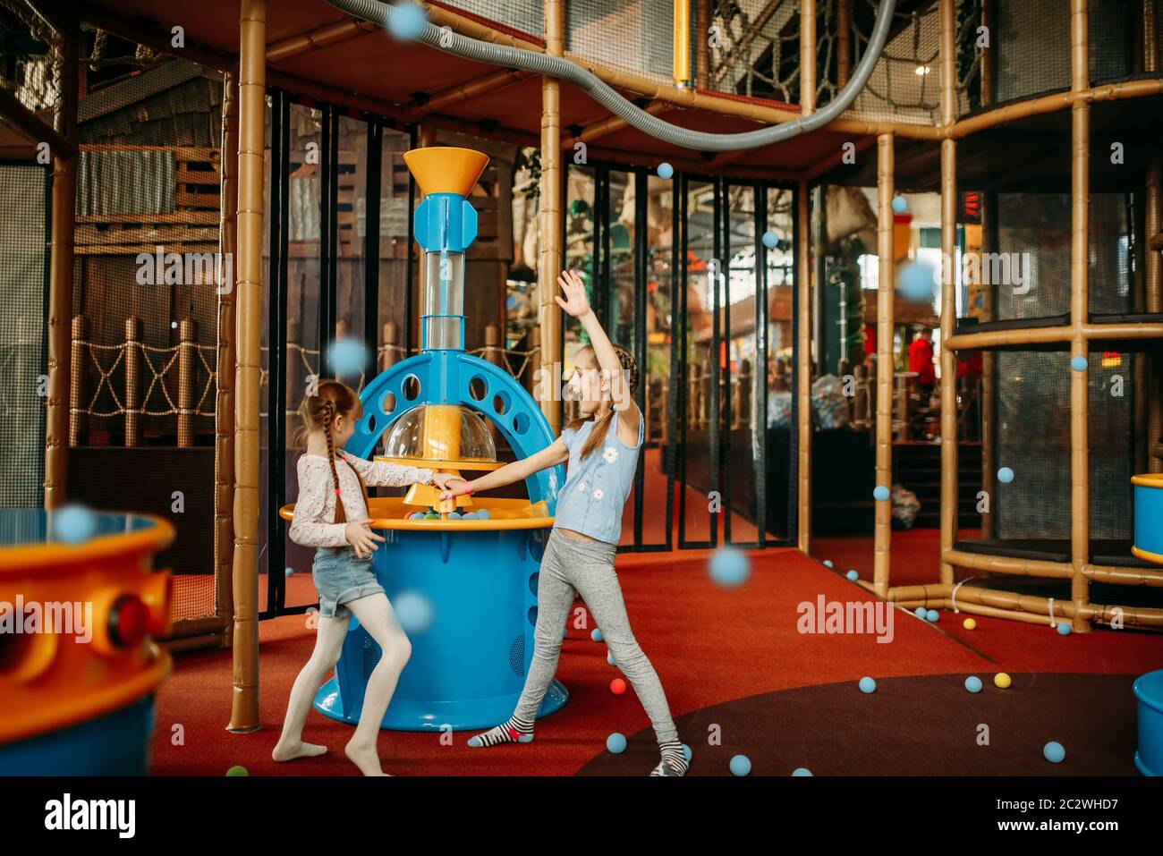 Two little girls plays air gun machine in children game center. Excited ...
