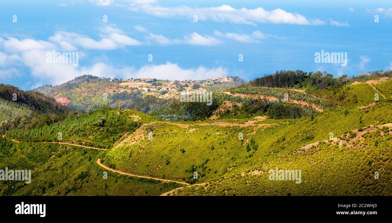 Up view of green mountains and towns against ocean Stock Photo - Alamy