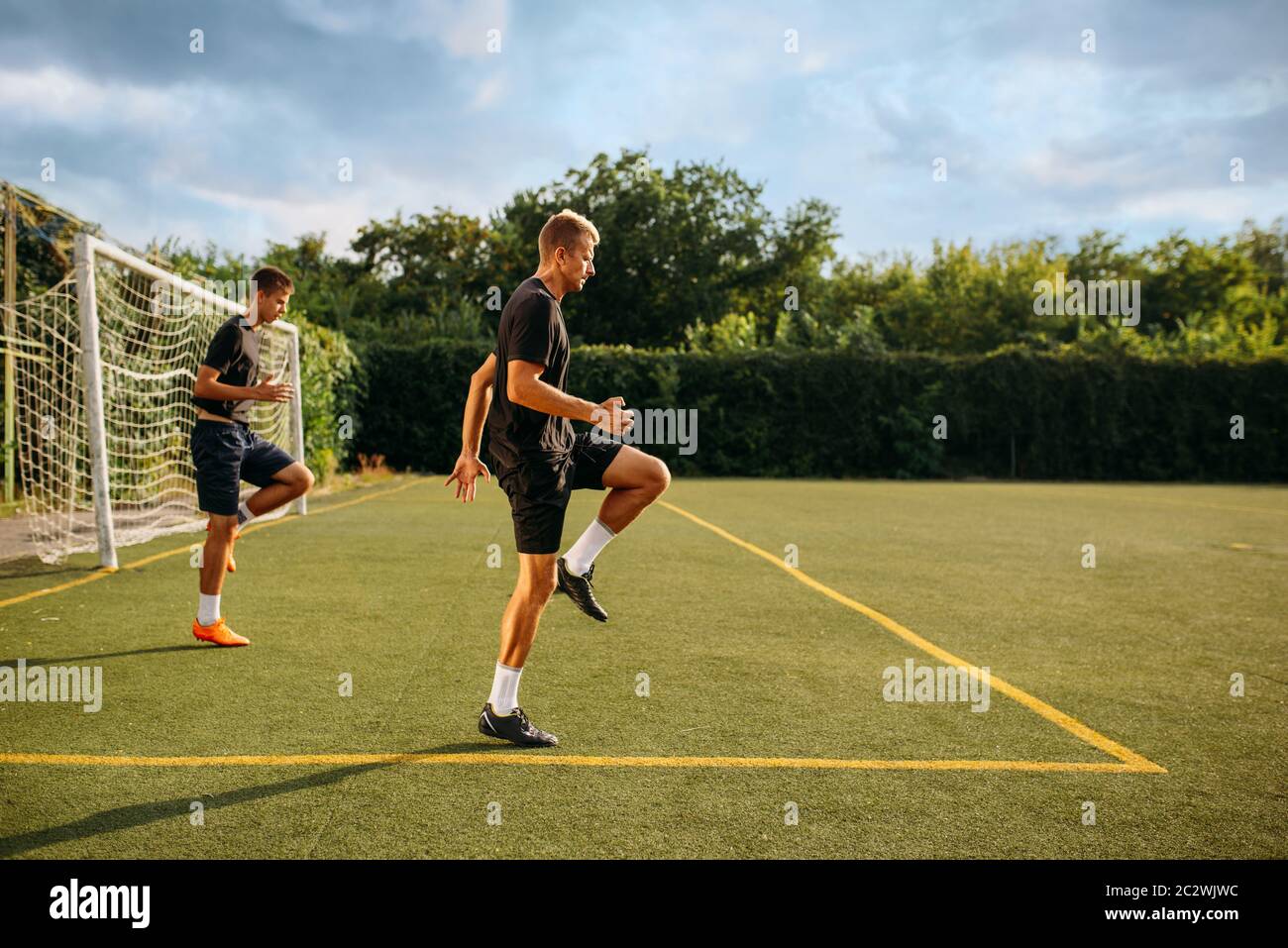 Two male soccer players training on the field. Footballers on outdoor ...