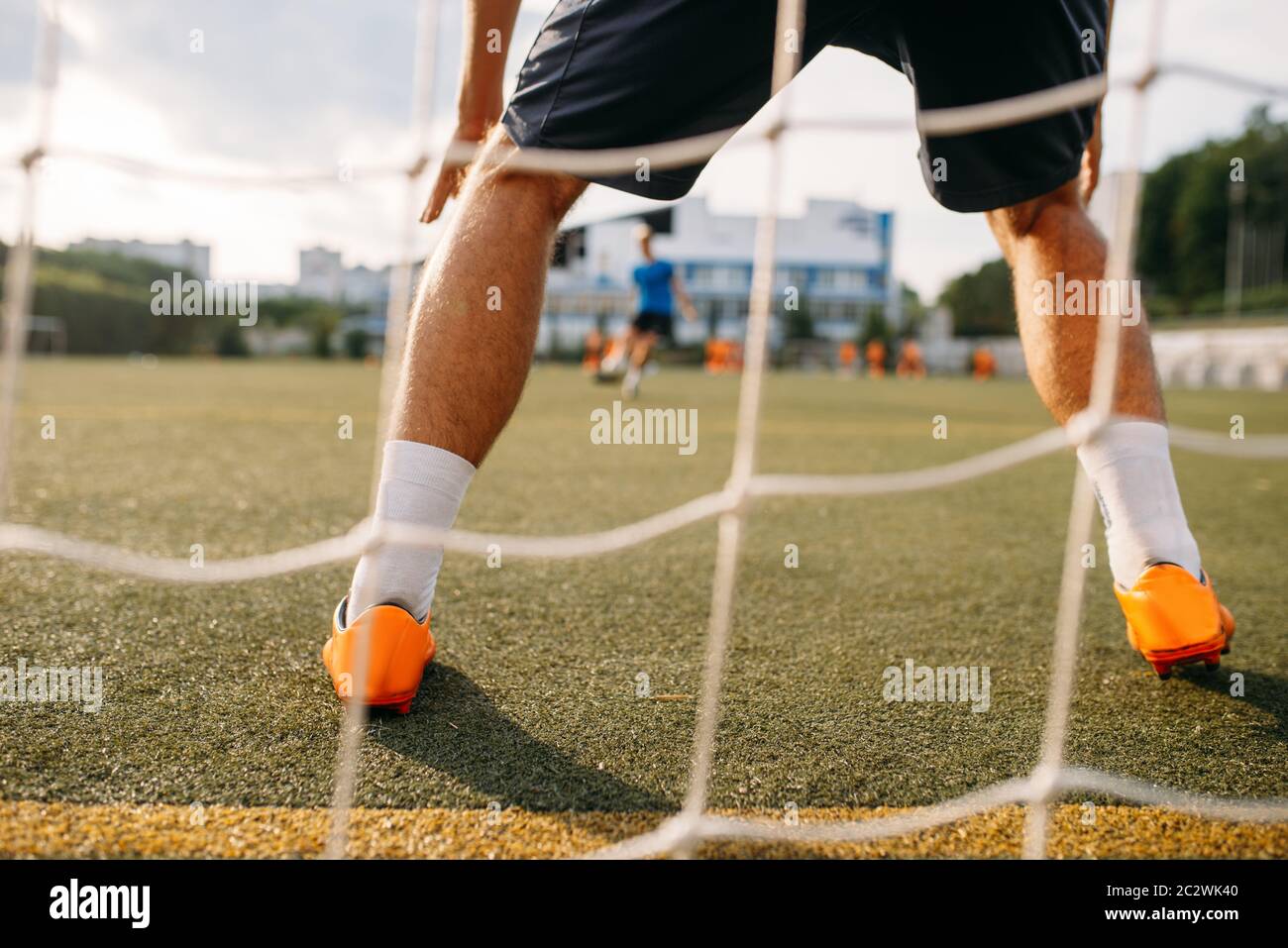 Male soccer goalkeeper stands on the gate, back view. Footballer on ...