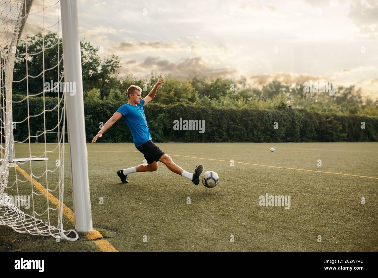 Male soccer goalkeeper hits the ball and saves the gate. Footballer on ...