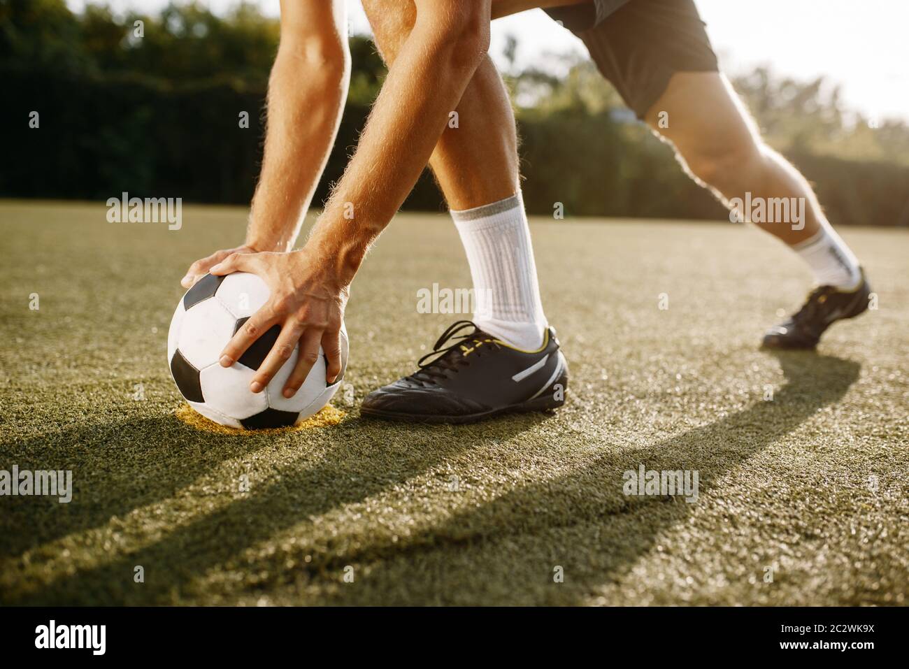 Male soccer player prepares to hits the ball on the field. Footballer ...