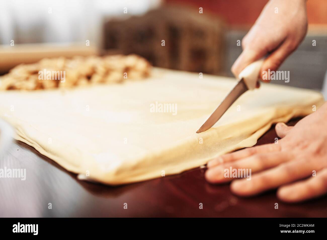 Male chef prepares apple strudel on wooden kitchen table, pastry ...