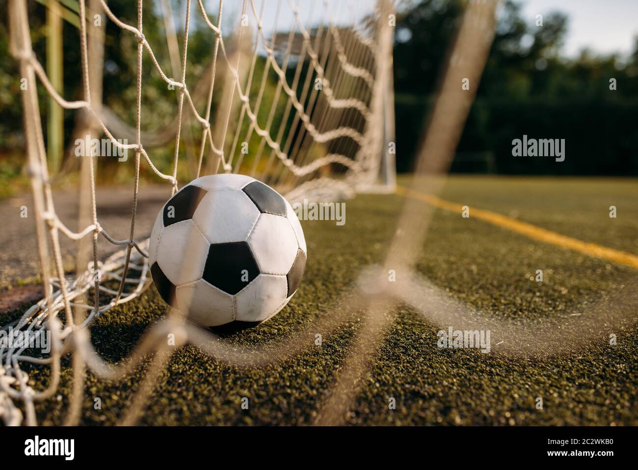 Soccer ball in the gate net, nobody. Football on outdoor stadium, sport ...