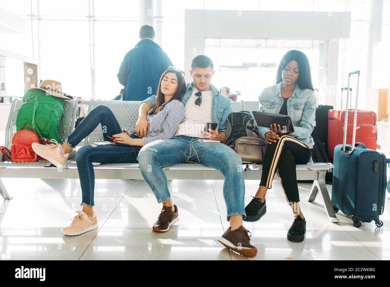 Group of tourists with luggage waiting for delayed departure in airport ...
