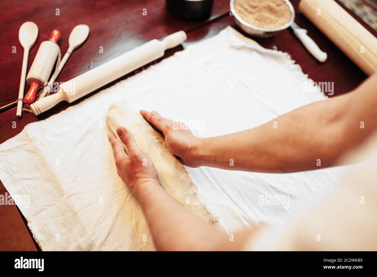 Male chef prepares classical apple strudel, top view, bakery cooking ...