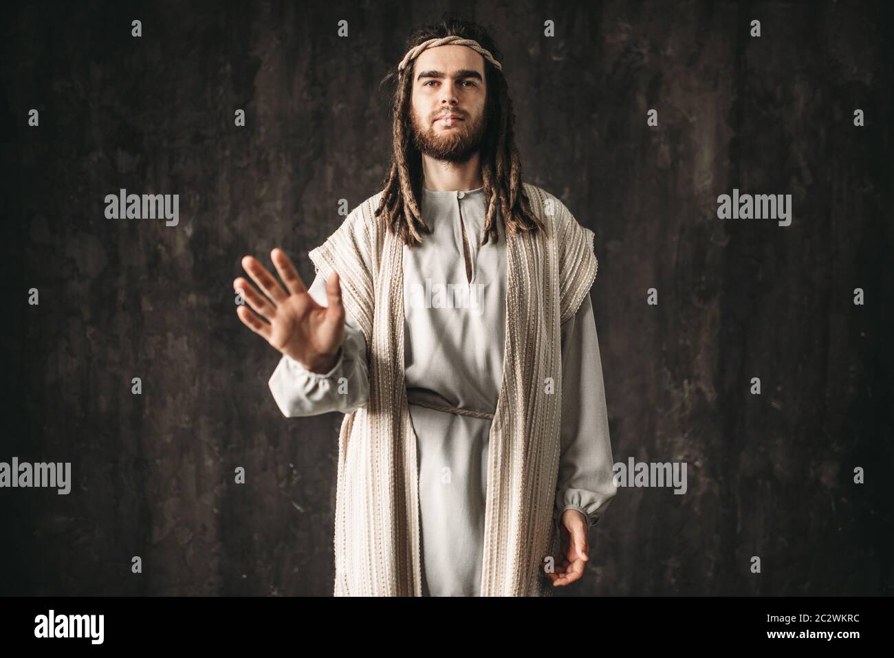 Jesus Christ in white robe reaching out his hand, window with sunlight ...