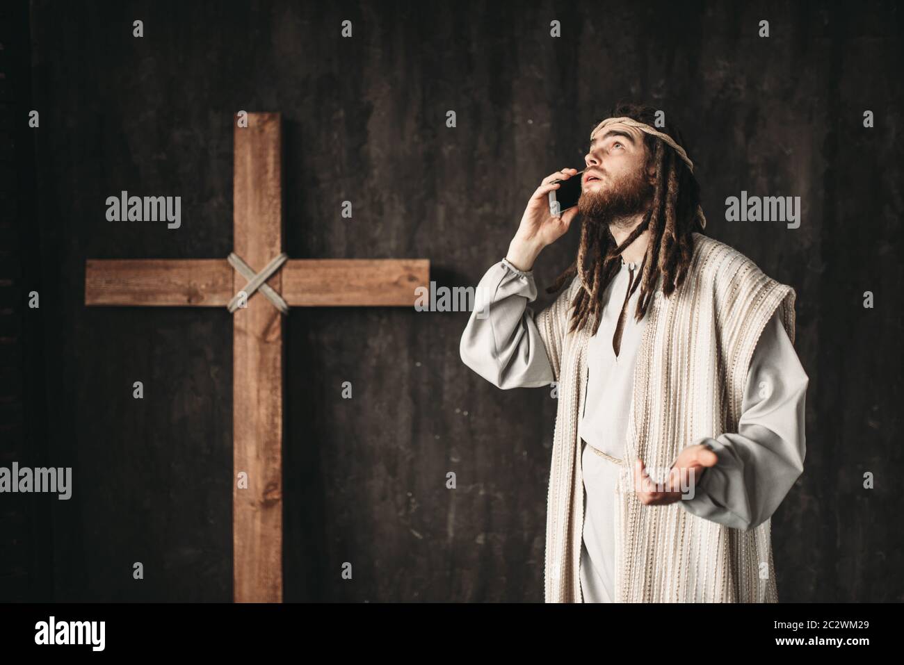 Man in the image of Jesus Christ talking to God by mobile phone ...