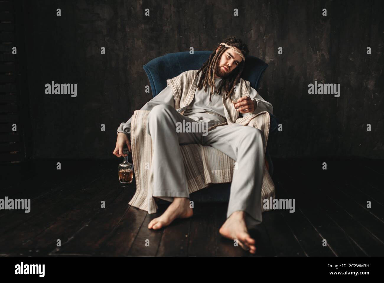 Drunken man in the image of Jesus Christ holds a stack and a bottle of ...