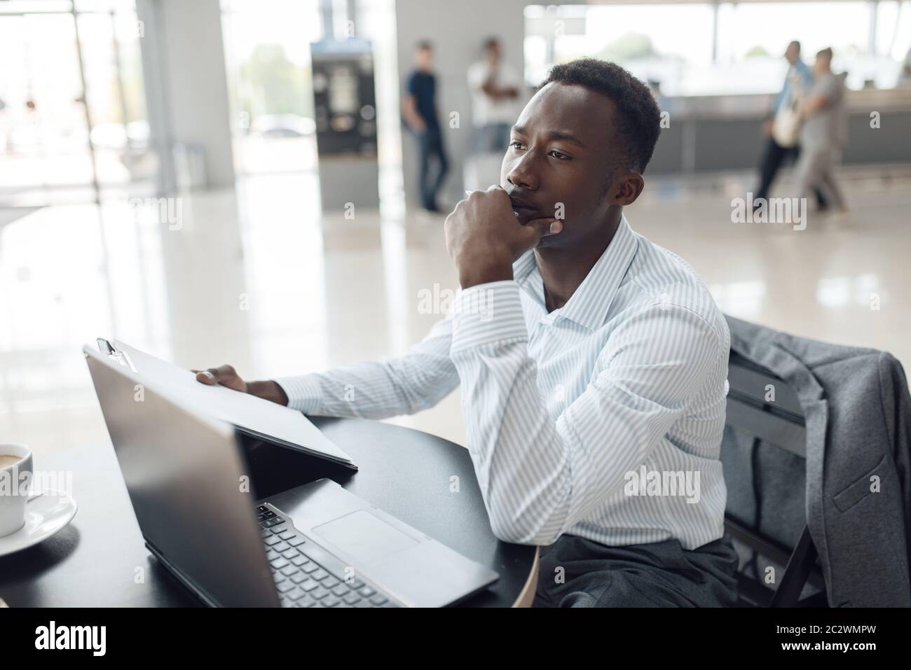 Black businessman sitting at laptop in car dealership. Successful ...