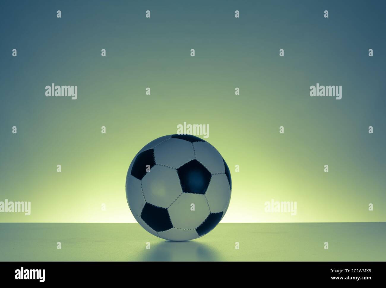 symbol picture of a football with yellow background Stock Photo - Alamy