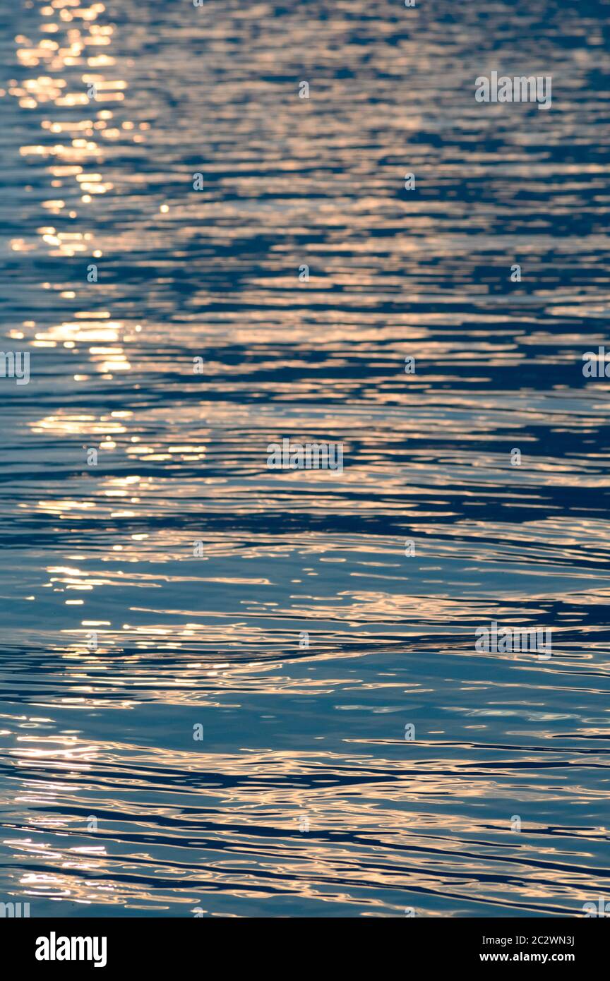 Sunset light reflecting on rippled water surface Stock Photo - Alamy