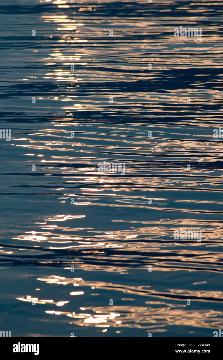 Sunset light reflecting on rippled water surface Stock Photo - Alamy