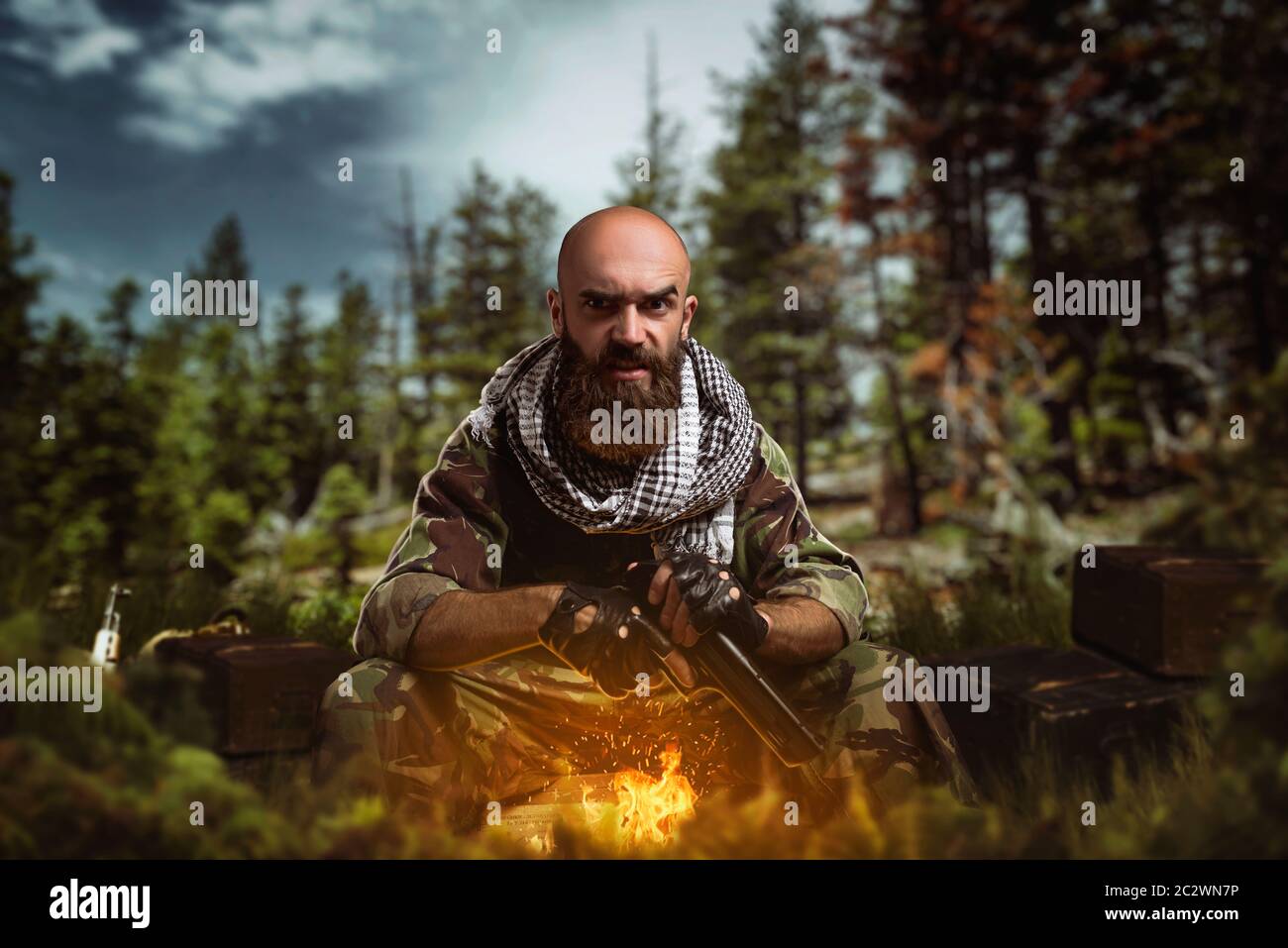 Cruel terrorist in uniform with gun in hands hiding in the forest ...