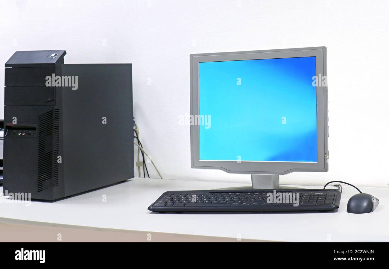 Computer with blue screen and keyboard inside modern room interior ...