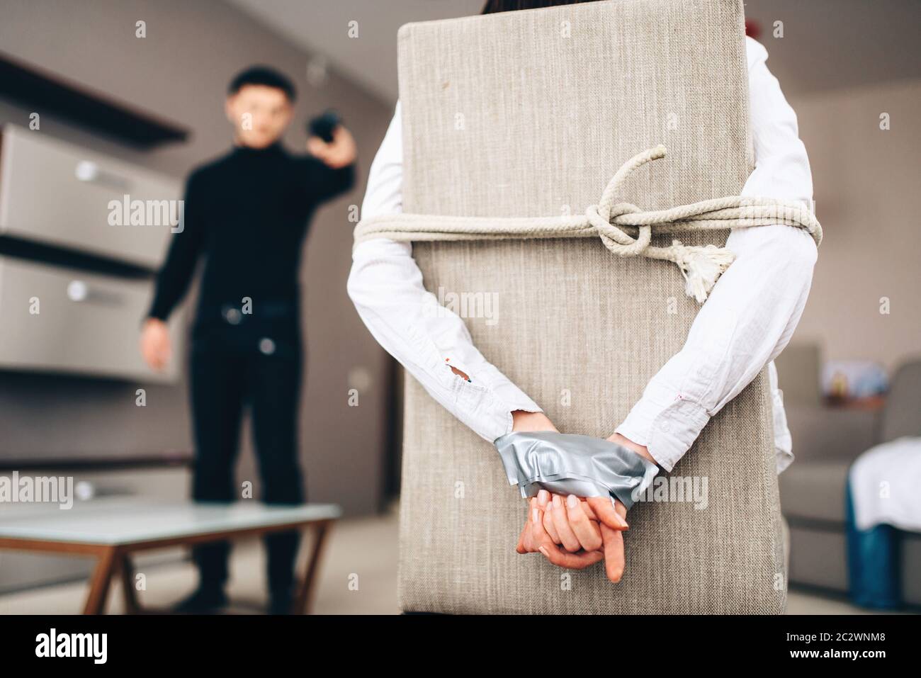 Robber In Black Clothes Scares The Victim Tied With Rope And Tape To