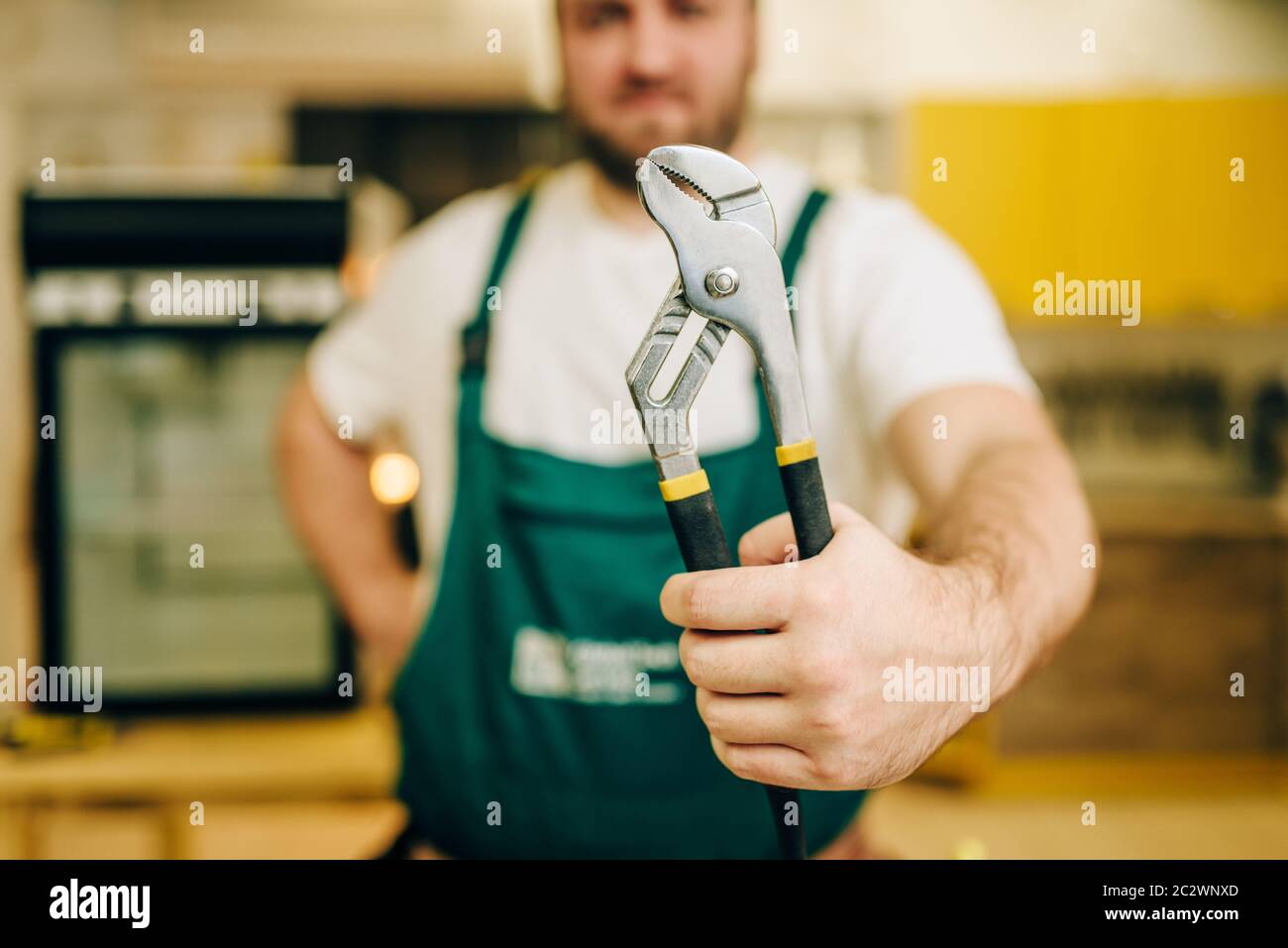 Repairman in uniform holds wrench, handyman. Professional worker makes ...