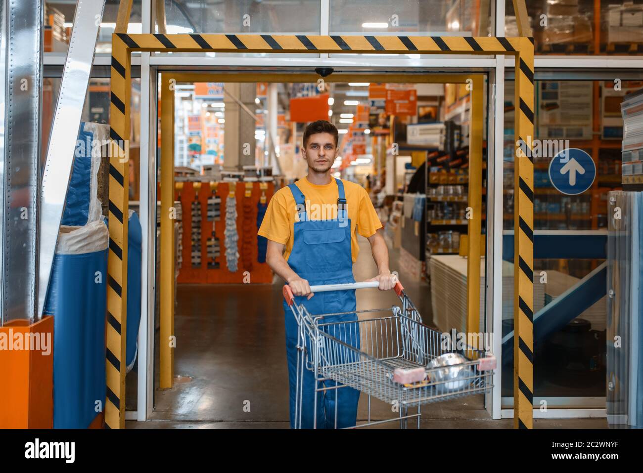 Male builder carries building materials in a cart, hardware store ...